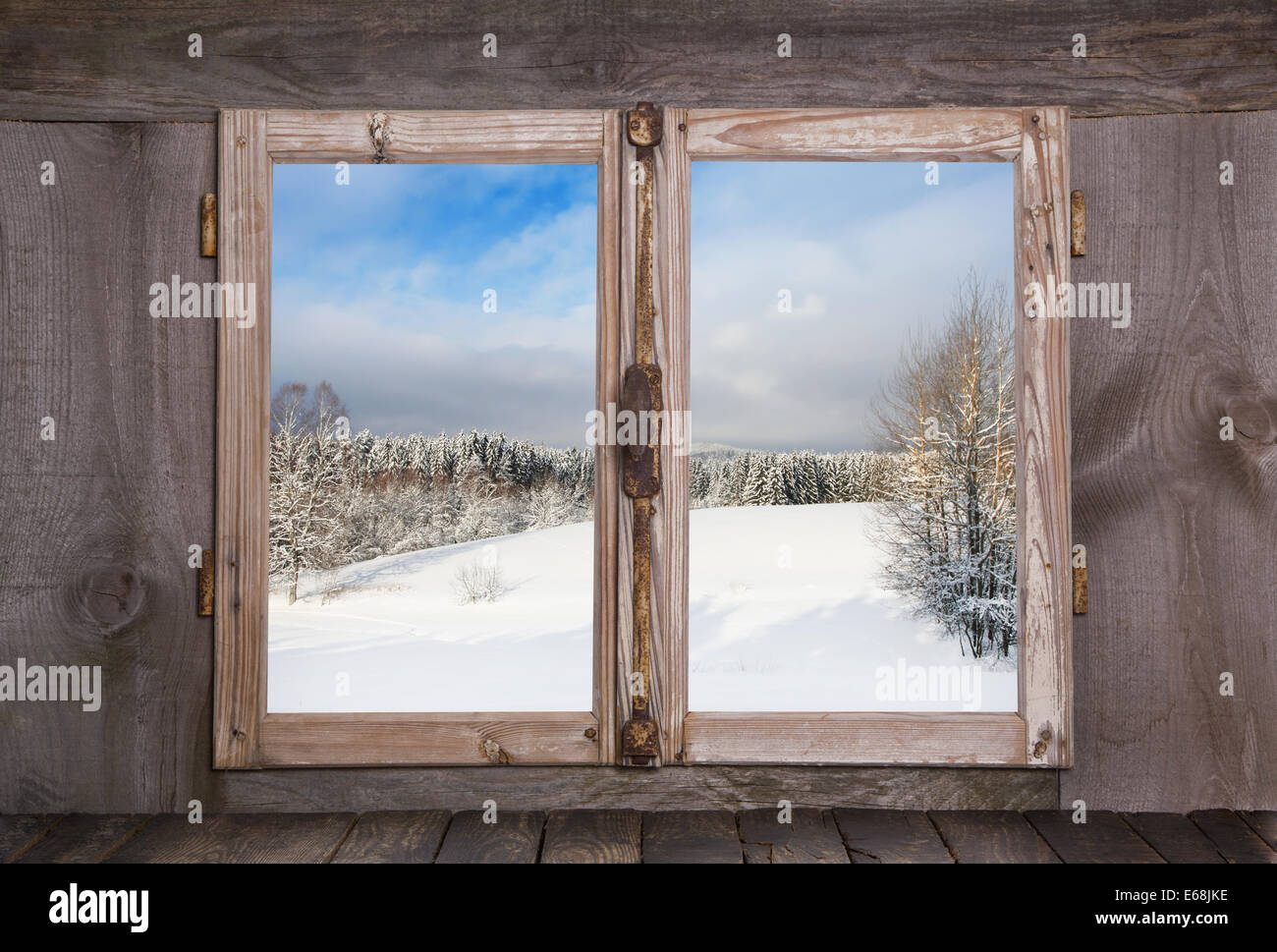 Snowy winter landscape in january. View out of an old rustic wooden ...