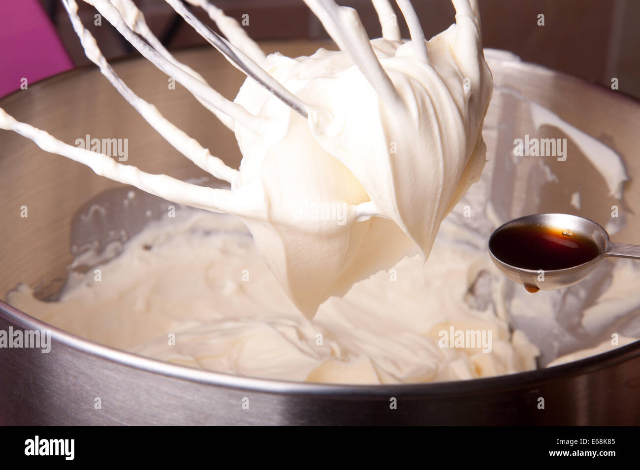 adding vanilla extract to the mixed cream Stock Photo - Alamy