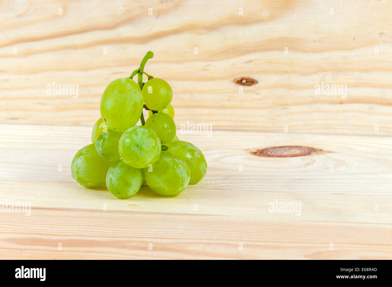Fresh green grapes on light wooden background Stock Photo - Alamy