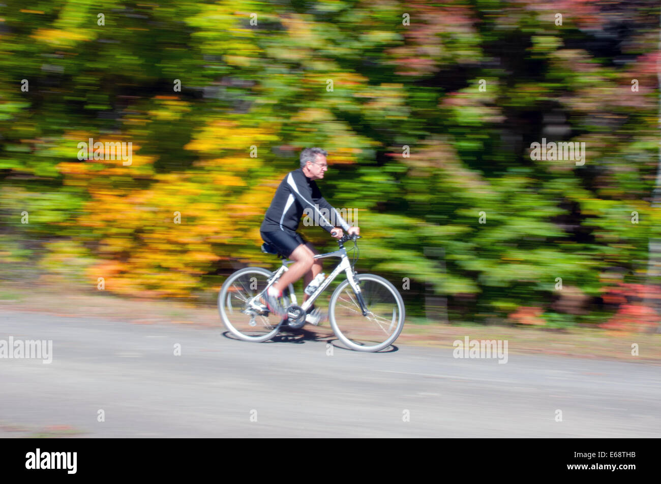 Cyclist speeding autumn Stock Photo - Alamy