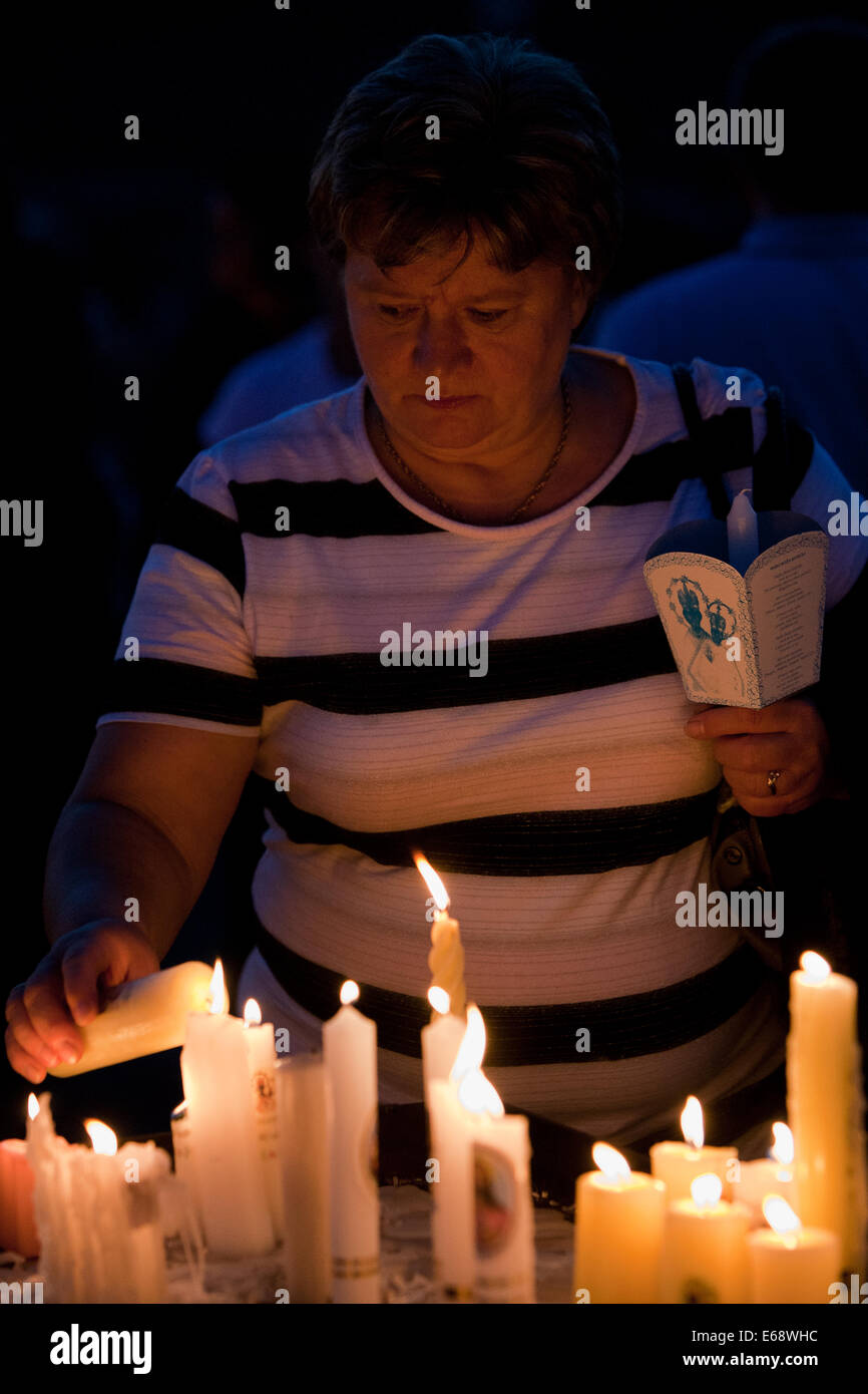 Woman lightning candles during pilgrimage, Marija Bistrica, Croatia ...