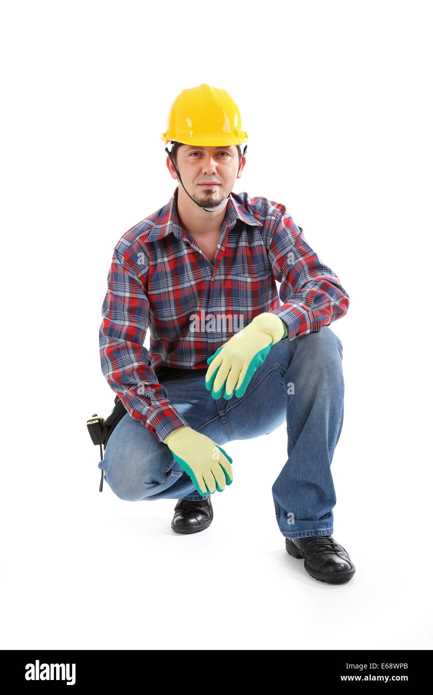 A construction worker squats down and grins for the camera Stock Photo ...