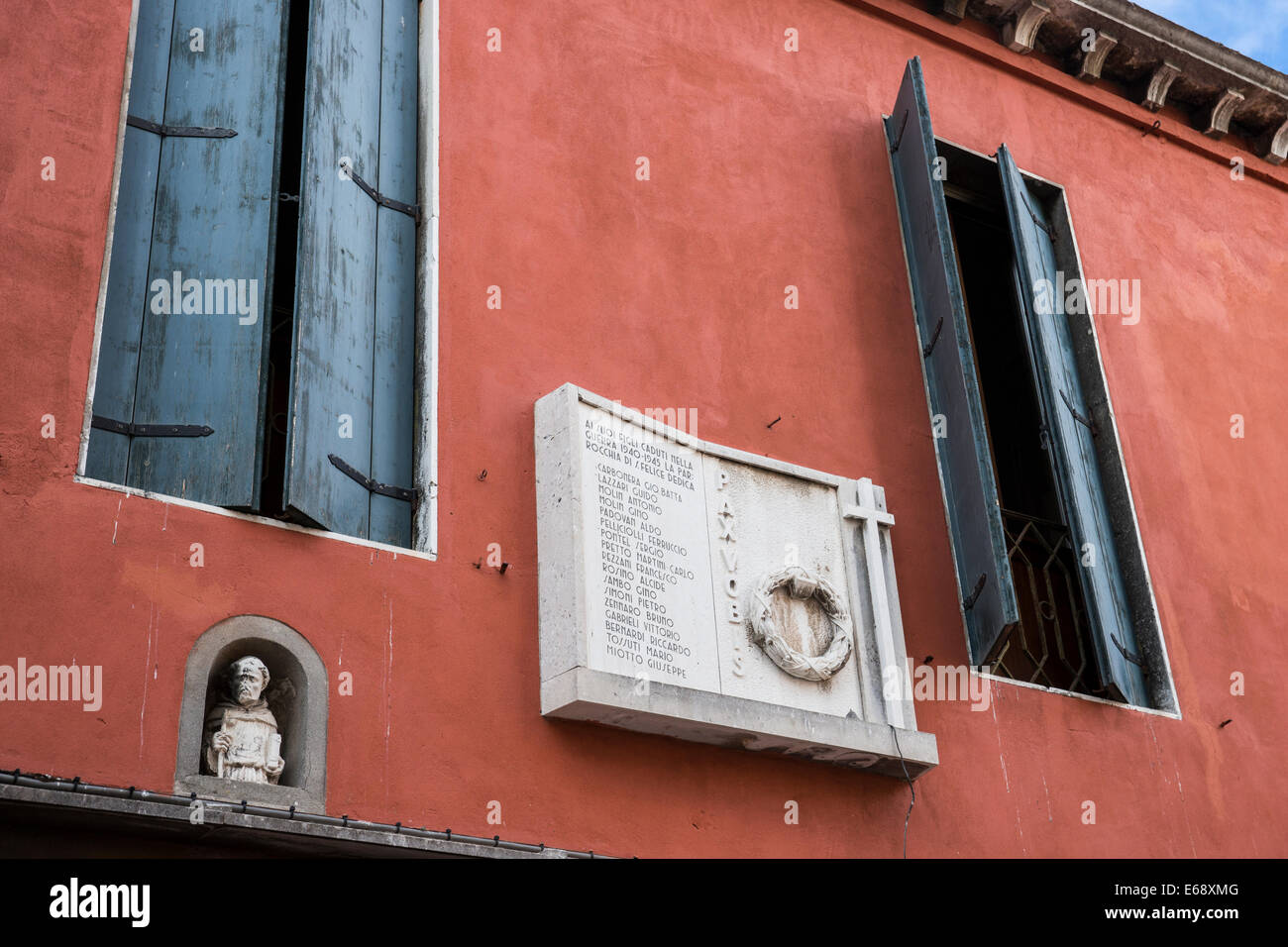 Upper floor of house in Venice with green shutters, a religious shrine ...