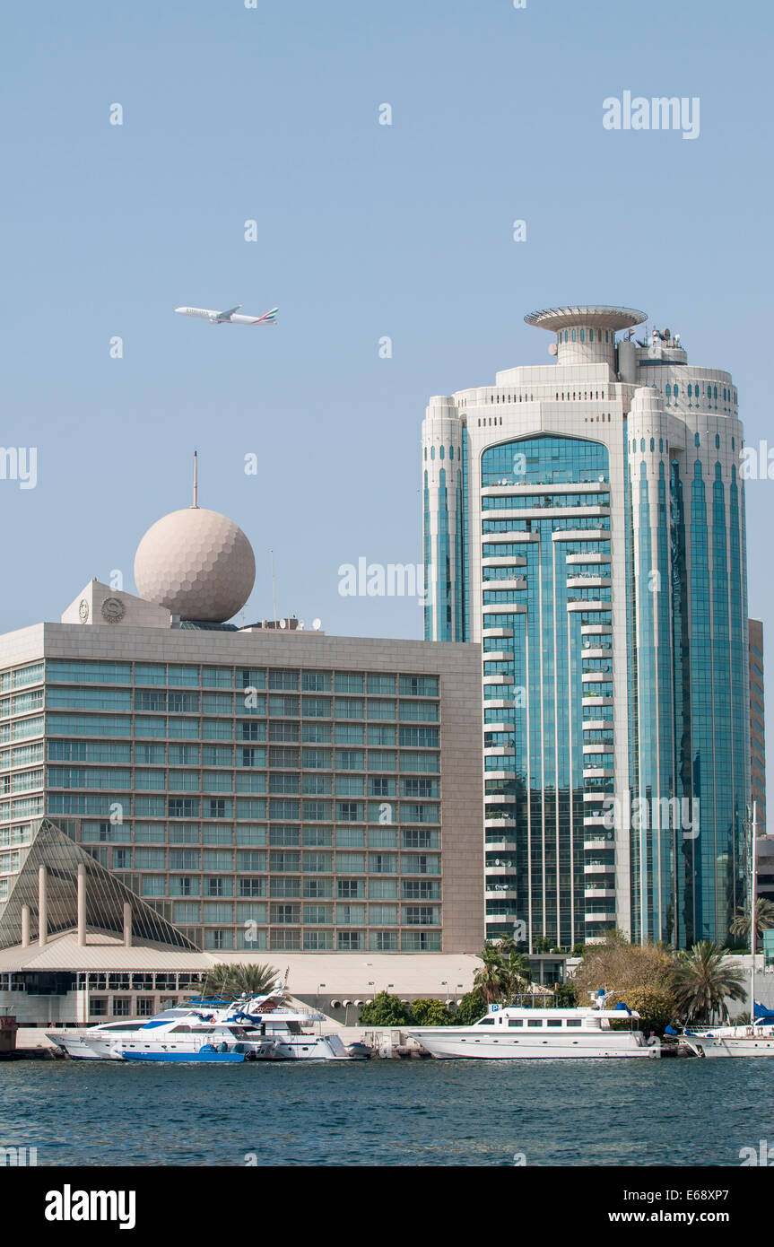 Jet airliner plane airplane over office building in the harbor Dubai ...
