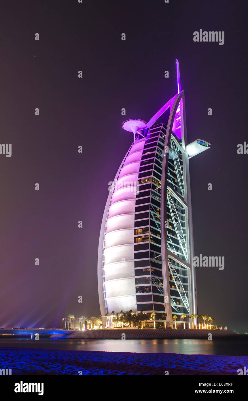 The sail shaped Burj Al Arab Hotel lit by colorful lights at night skyline Dubai, United Arab ...