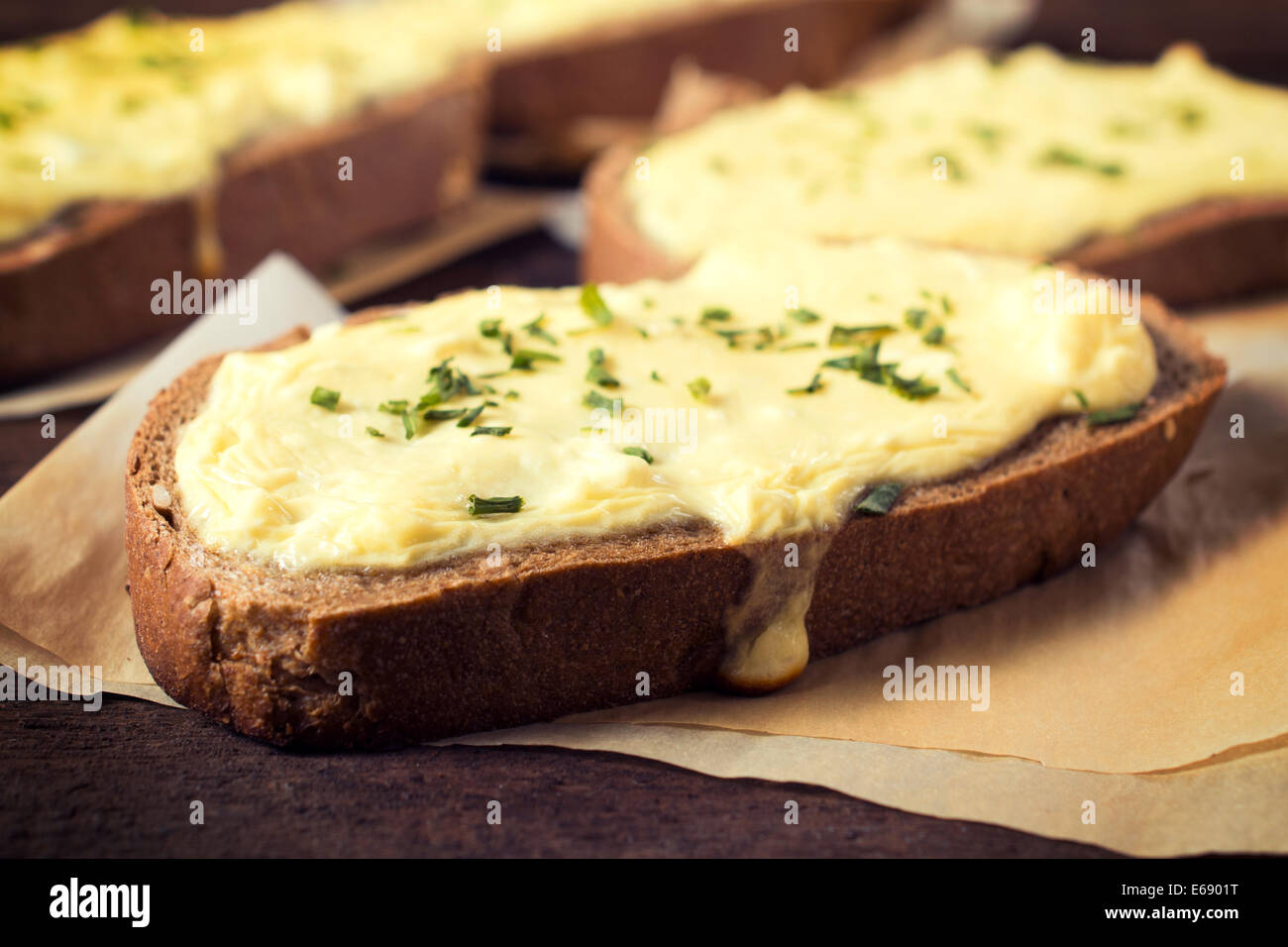 Selective focus on the front slice of bread with melted cheese on top ...