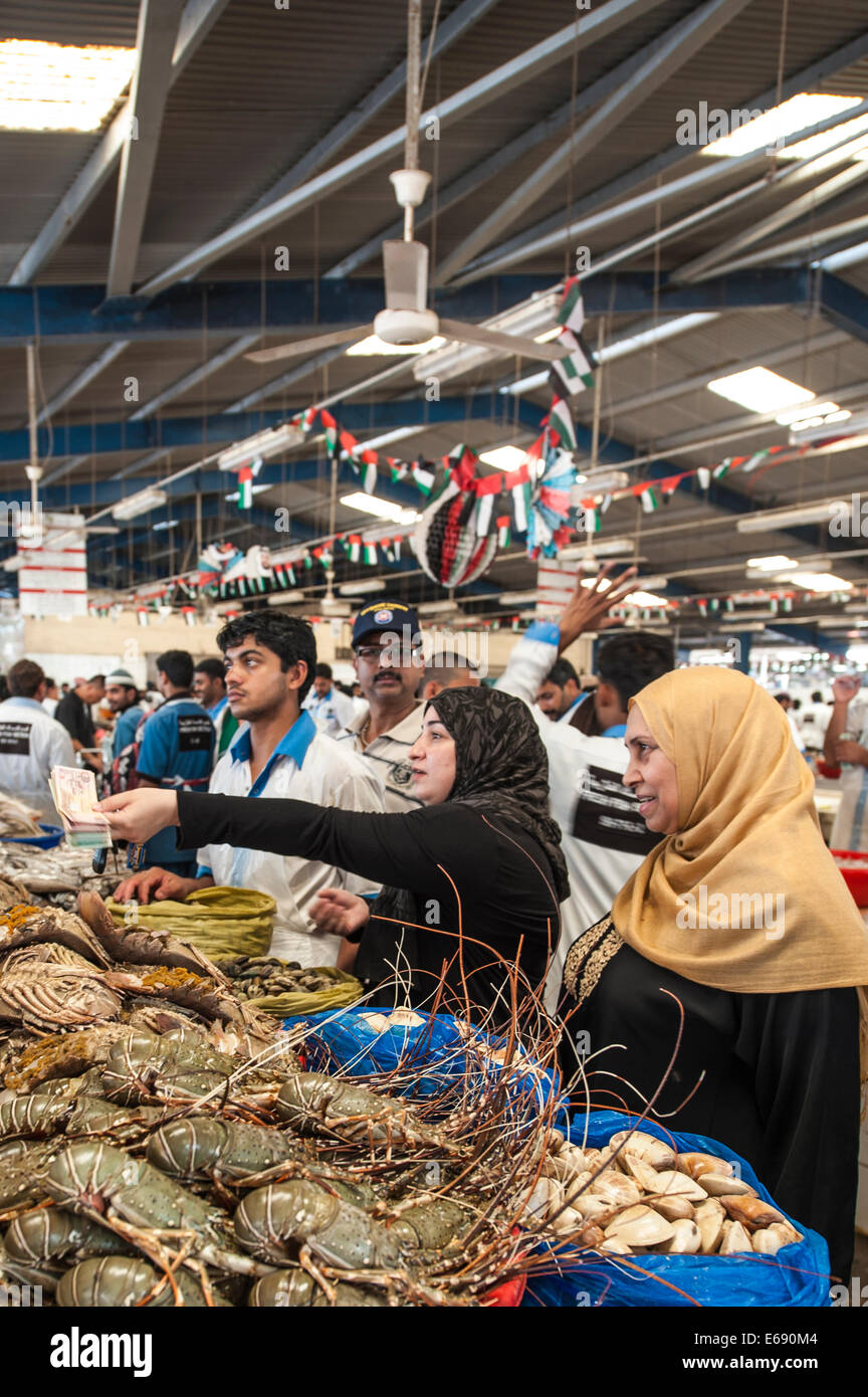 Fisherman with fish crab lobster shrimp in Deira fish market souk ...