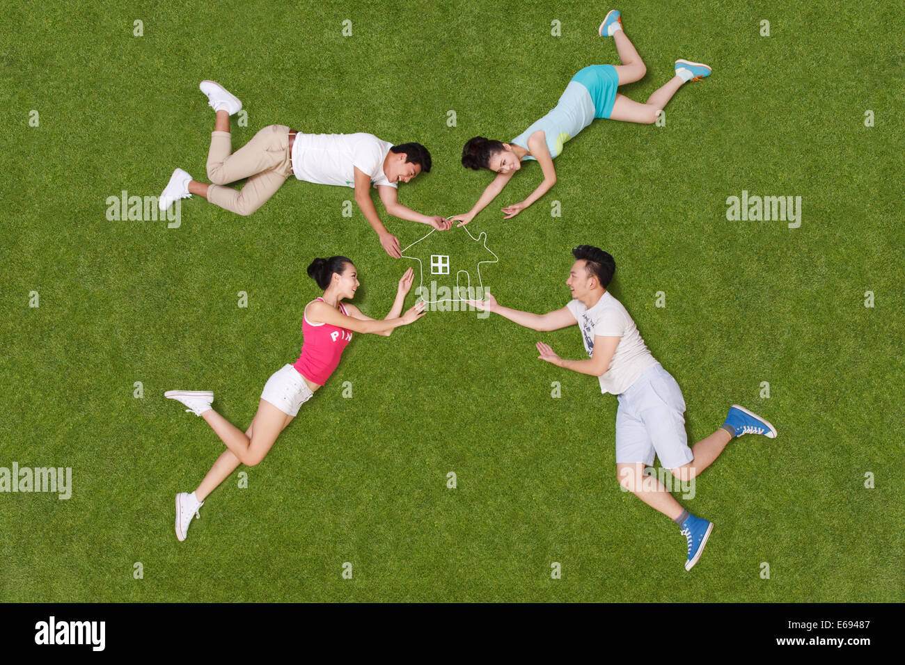 Young people lying on grass playing Stock Photo - Alamy