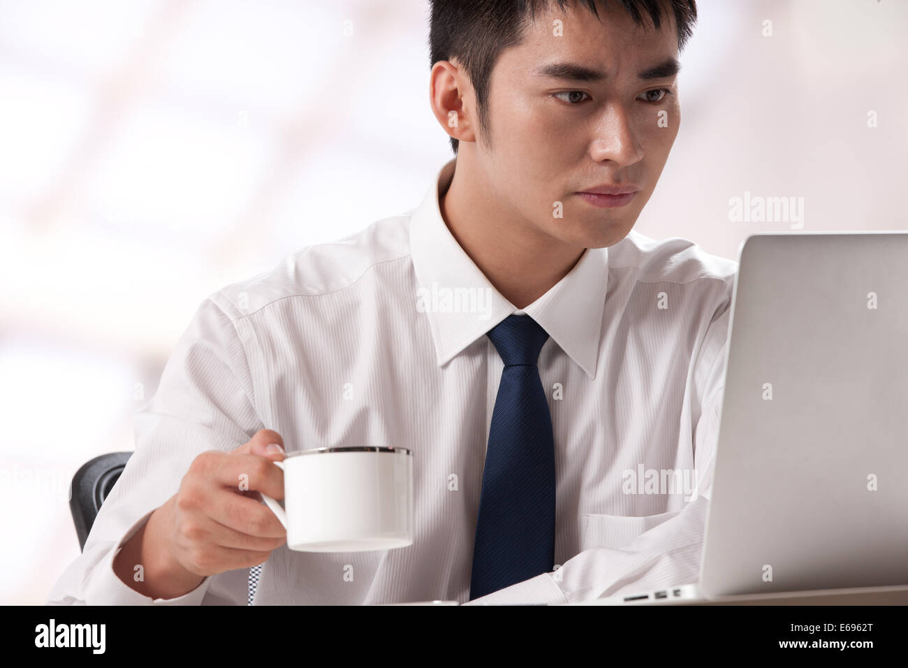Young businessman using laptop Stock Photo - Alamy