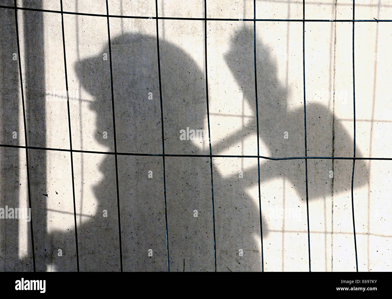 Shadow of a construction worker on a concrete wall, symbolic image for ...
