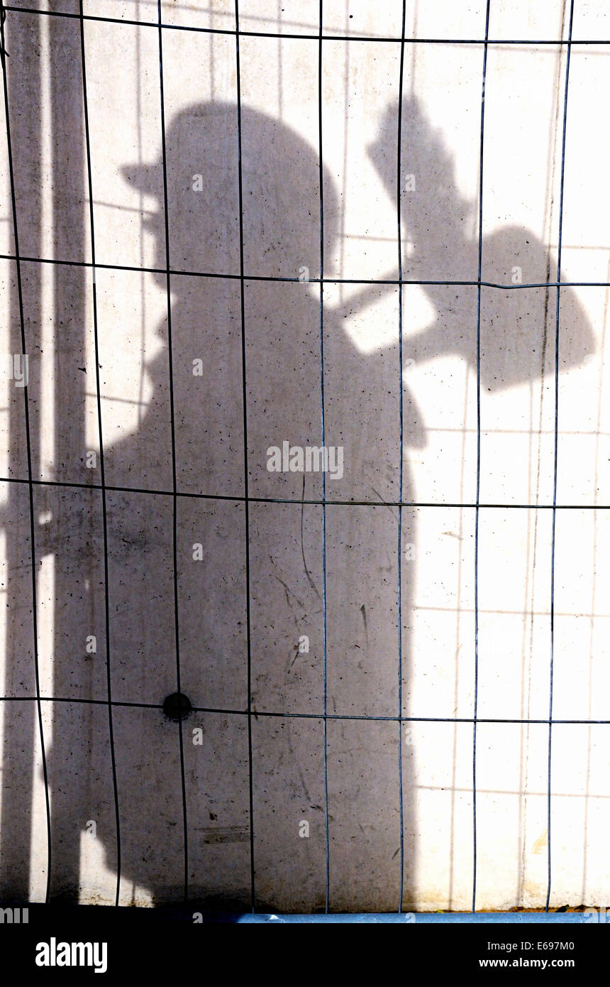 Shadow of a construction worker on a concrete wall, symbolic image for ...