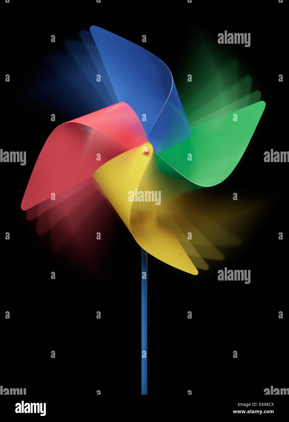 colorful pinwheel spinning against black background with motion blur ...