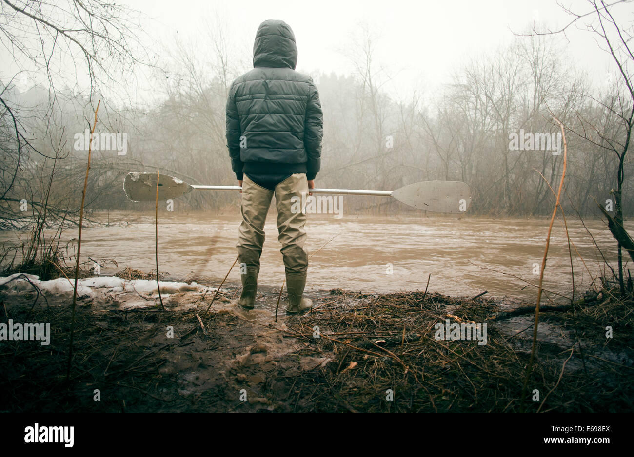 Mari man holding paddle by snowy river Stock Photo - Alamy