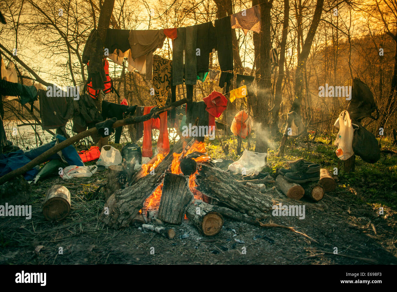 Clothes hanging over fire at campsite Stock Photo - Alamy