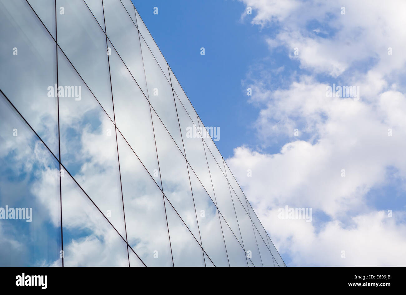 Blue sky and cloud reflected in the mirrored glass windows of a high ...