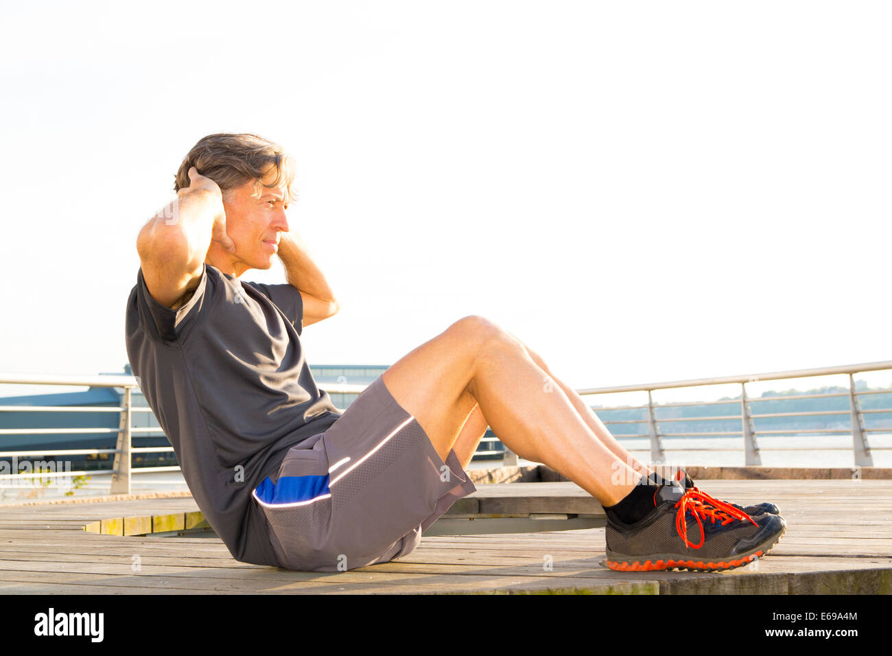 Caucasian man stretching in waterfront park Stock Photo - Alamy