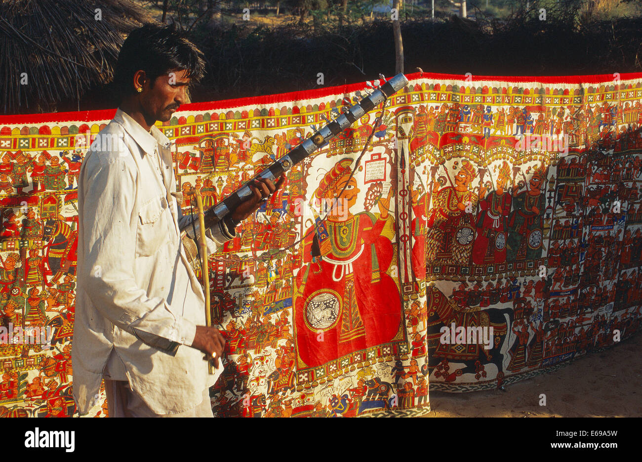 Minstrel playing music and singing a song in praise of the hindu god ...