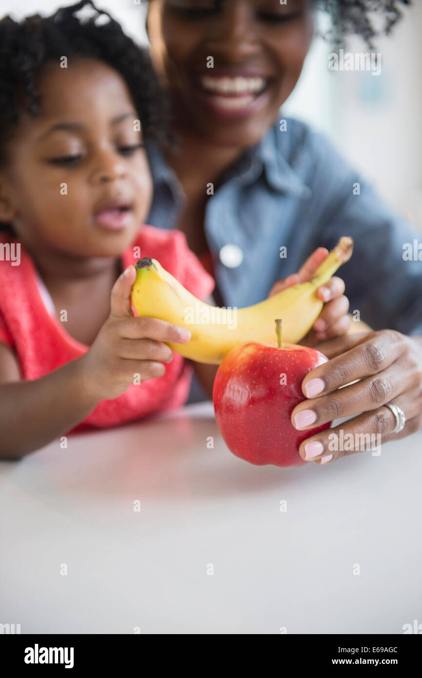 Mother and daughter playing with fruit Stock Photo - Alamy