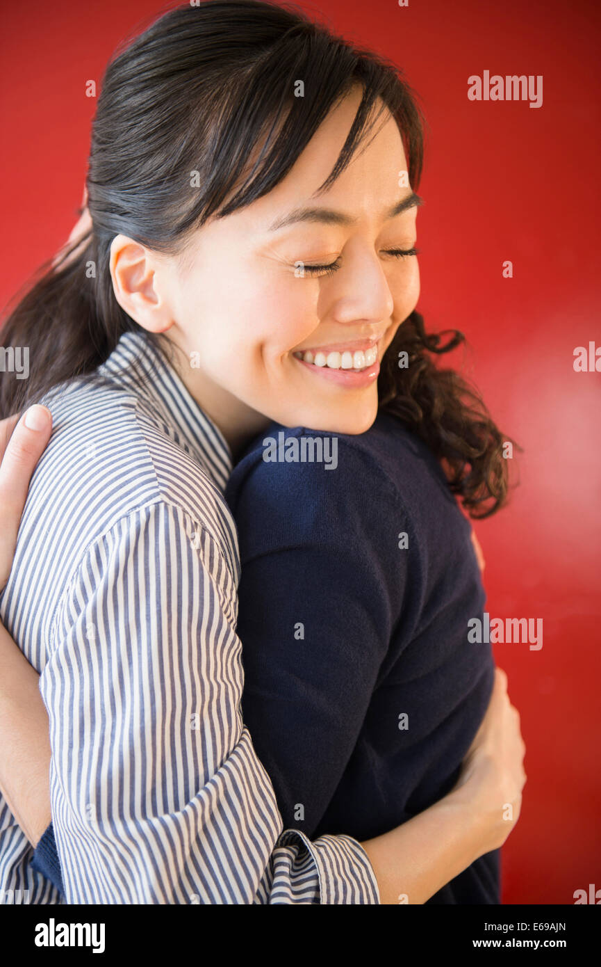 Smiling women hugging Stock Photo - Alamy