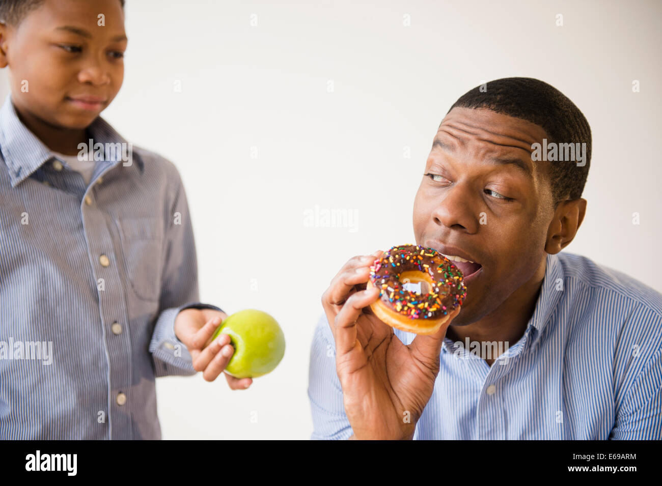Boy offering father healthy snack Stock Photo - Alamy