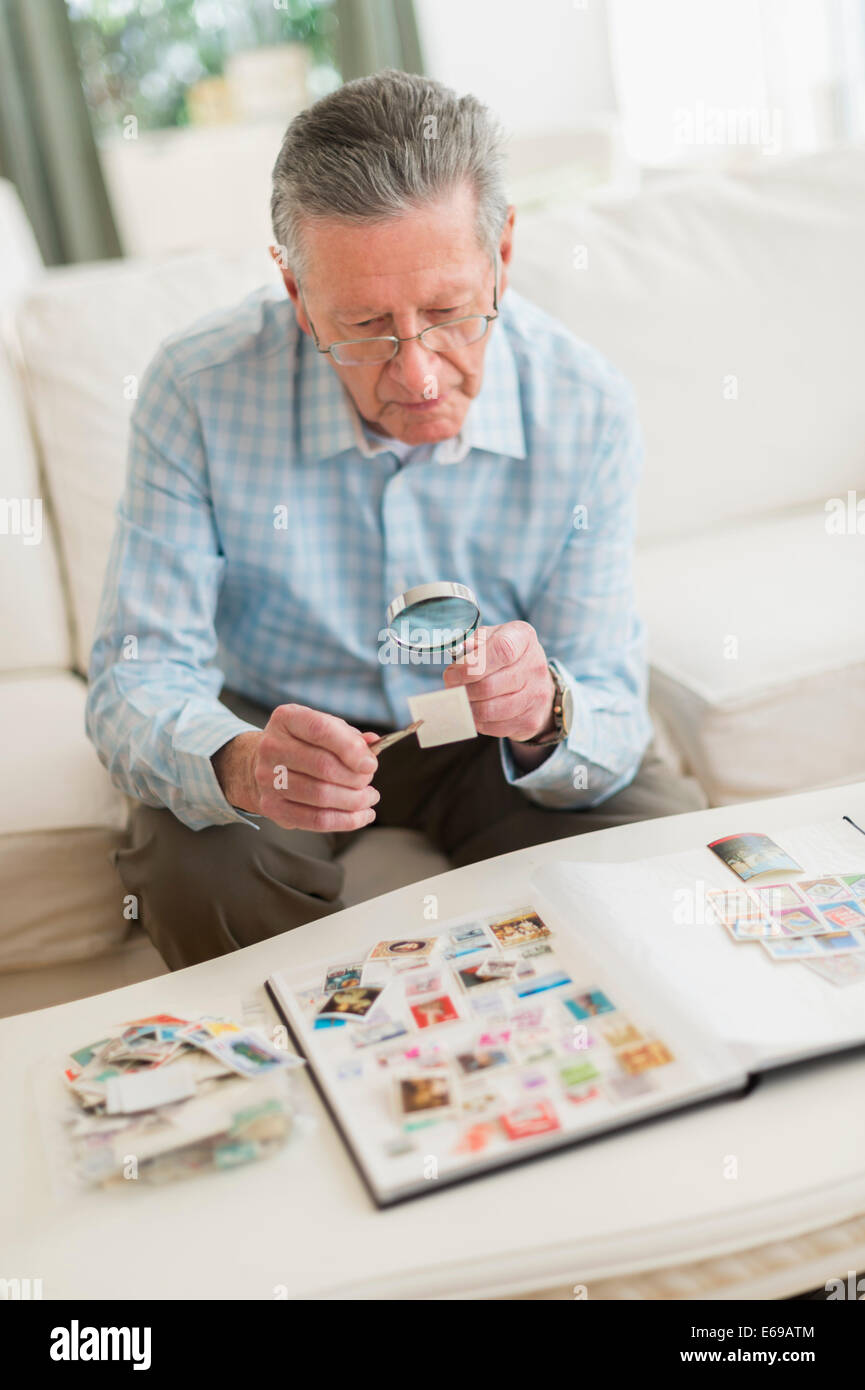 Senior Caucasian man examining stamp collection Stock Photo - Alamy