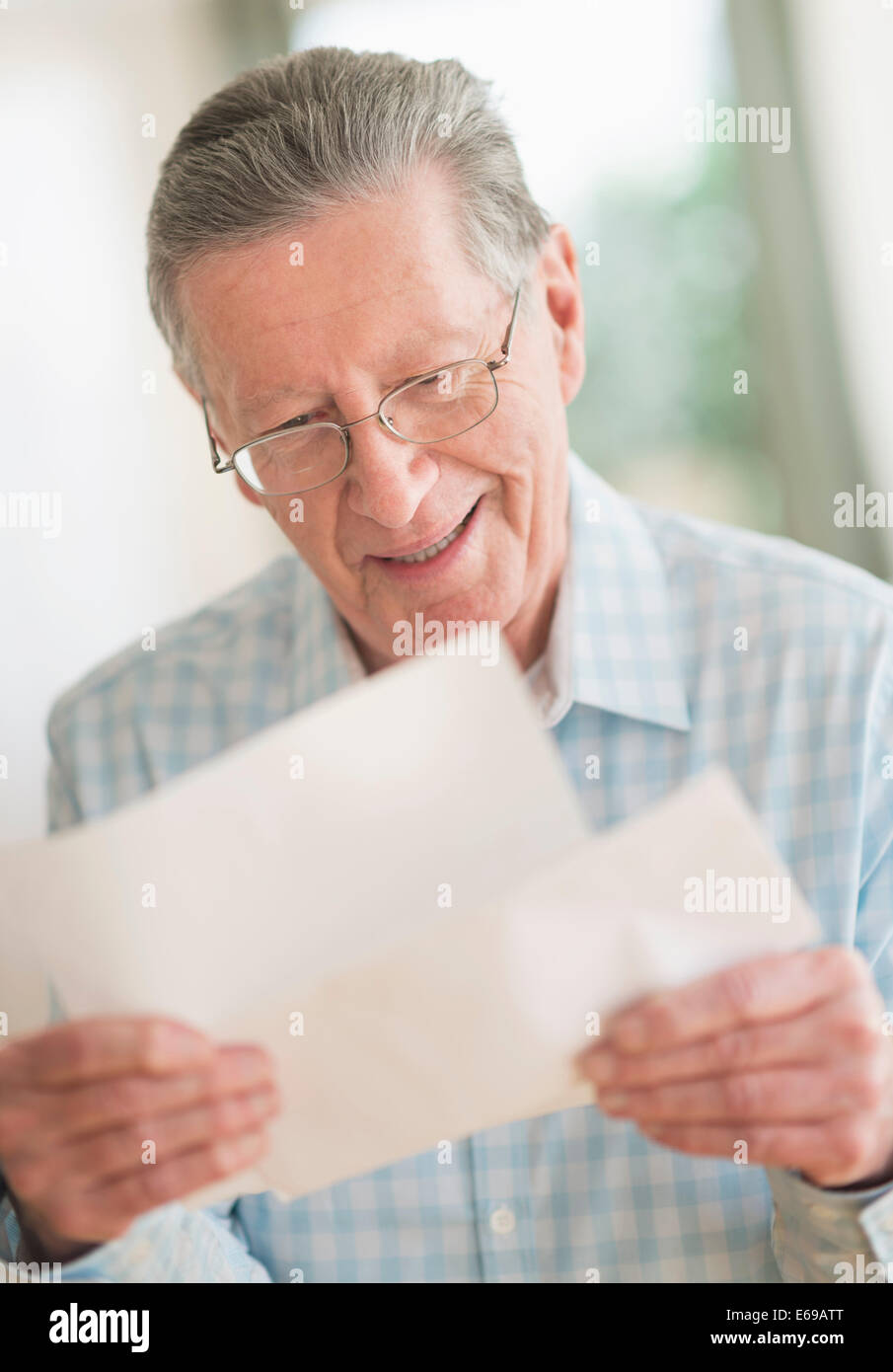 Senior Caucasian man reading letter Stock Photo - Alamy