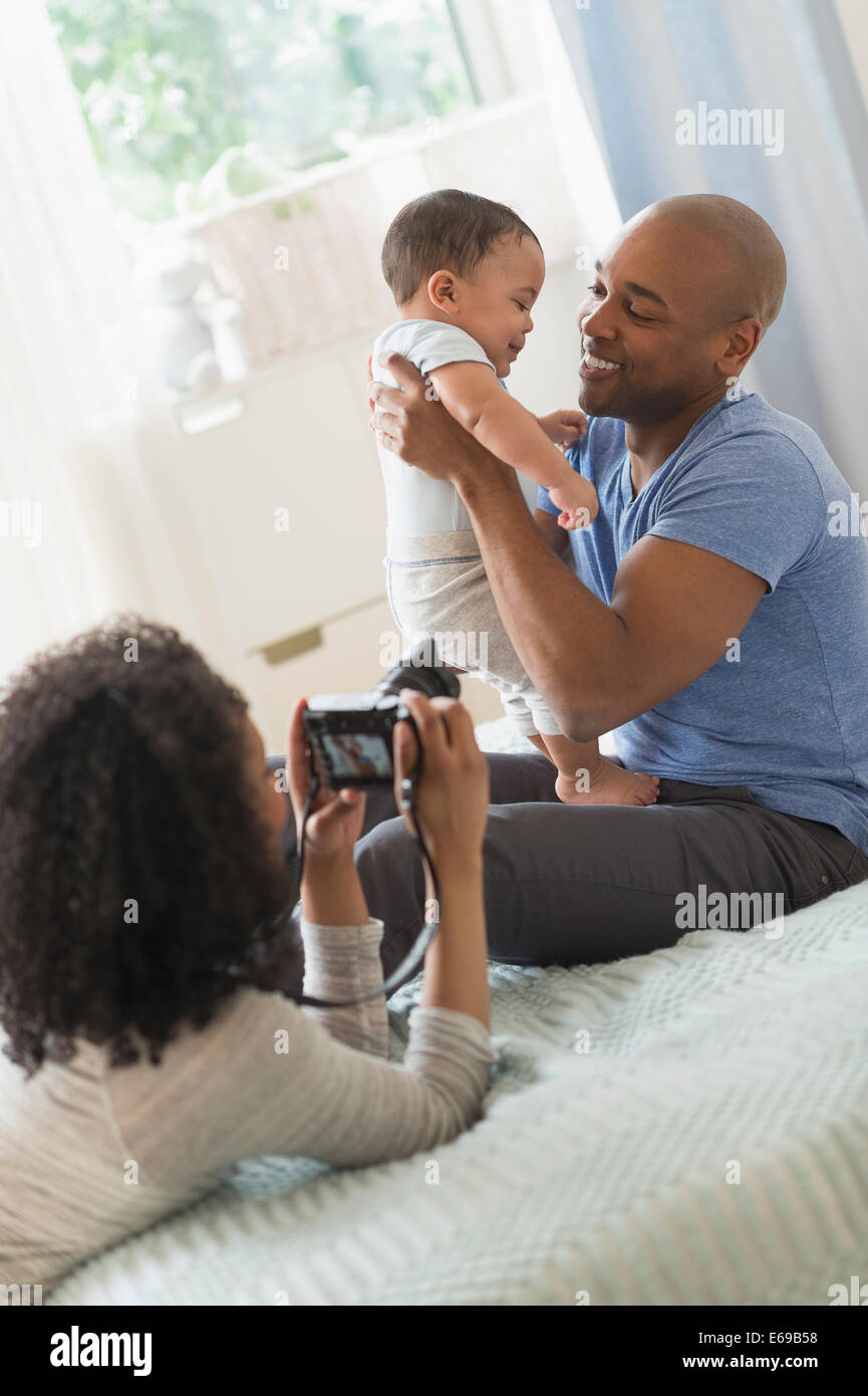 Woman taking picture of father and baby Stock Photo - Alamy