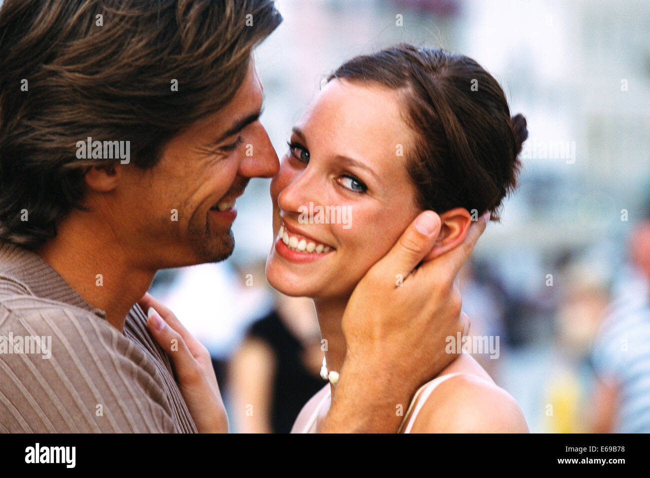Caucasian couple hugging on city street Stock Photo - Alamy