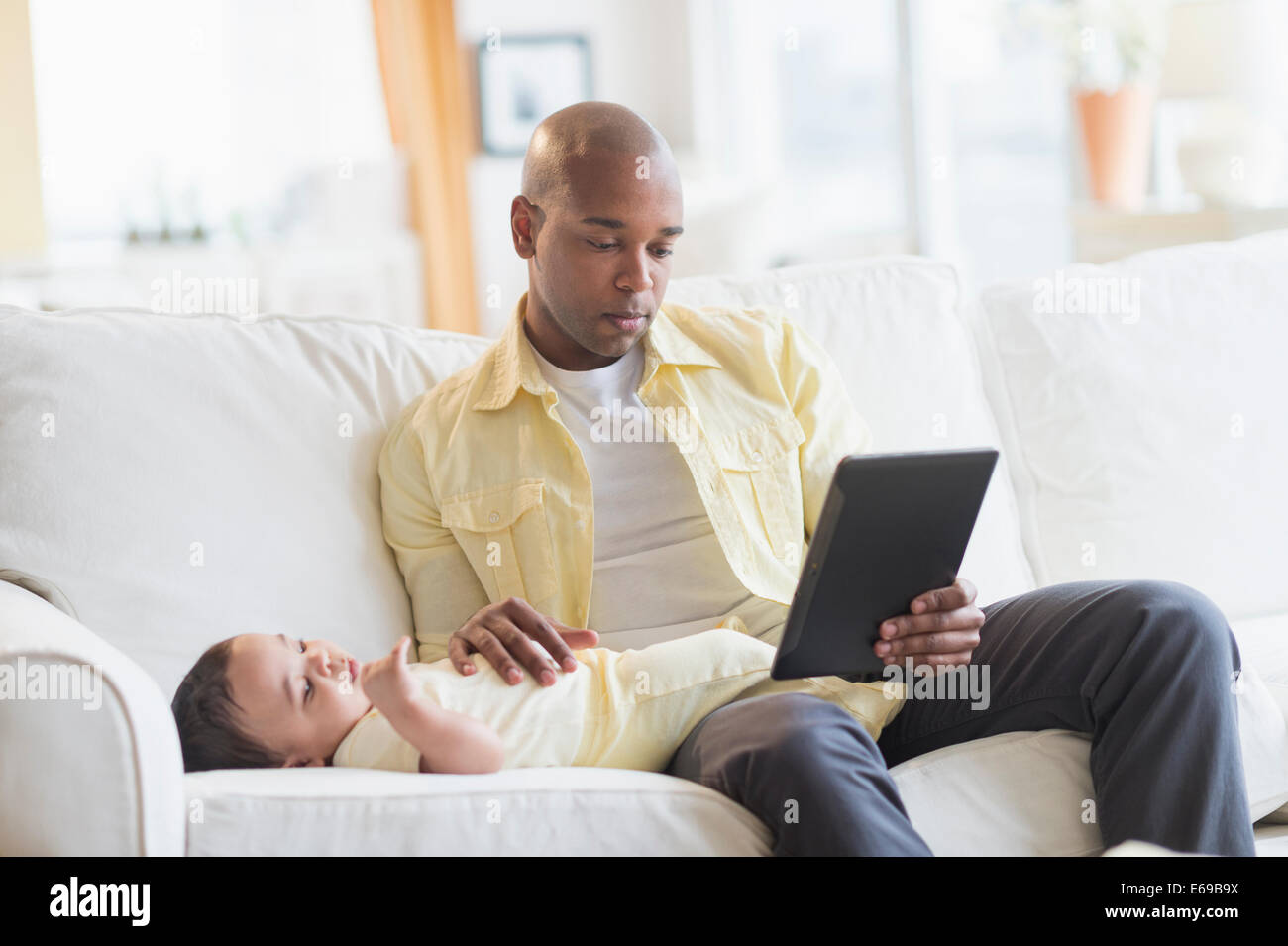 Smiling father relaxing with baby Stock Photo - Alamy