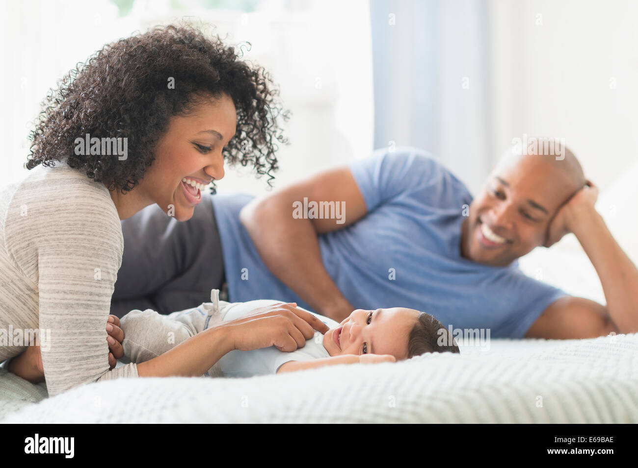 Family relaxing together on bed Stock Photo - Alamy
