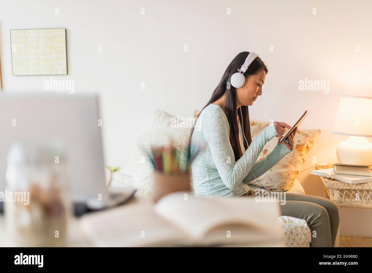Mixed race teenage girl using digital tablet on bed Stock Photo - Alamy