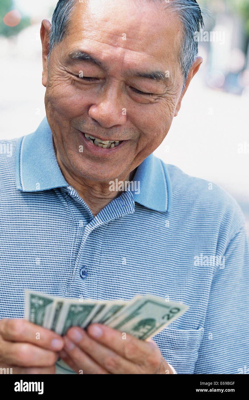 Senior man counting money outdoors Stock Photo - Alamy