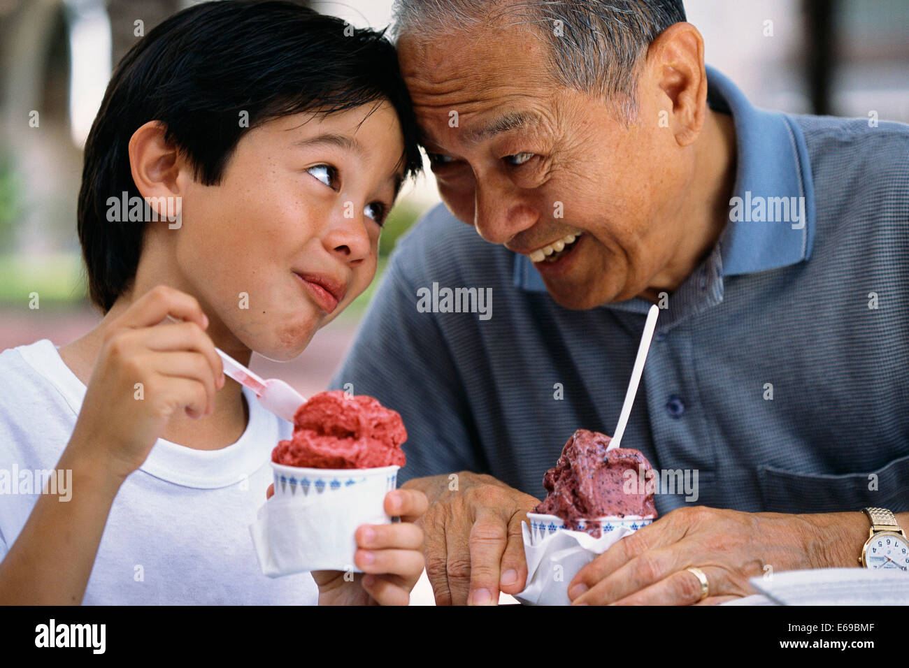Senior man and grandson eating ice cream outdoors Stock Photo - Alamy