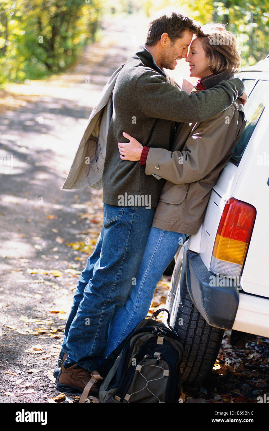 Couple hugging by car Stock Photo - Alamy