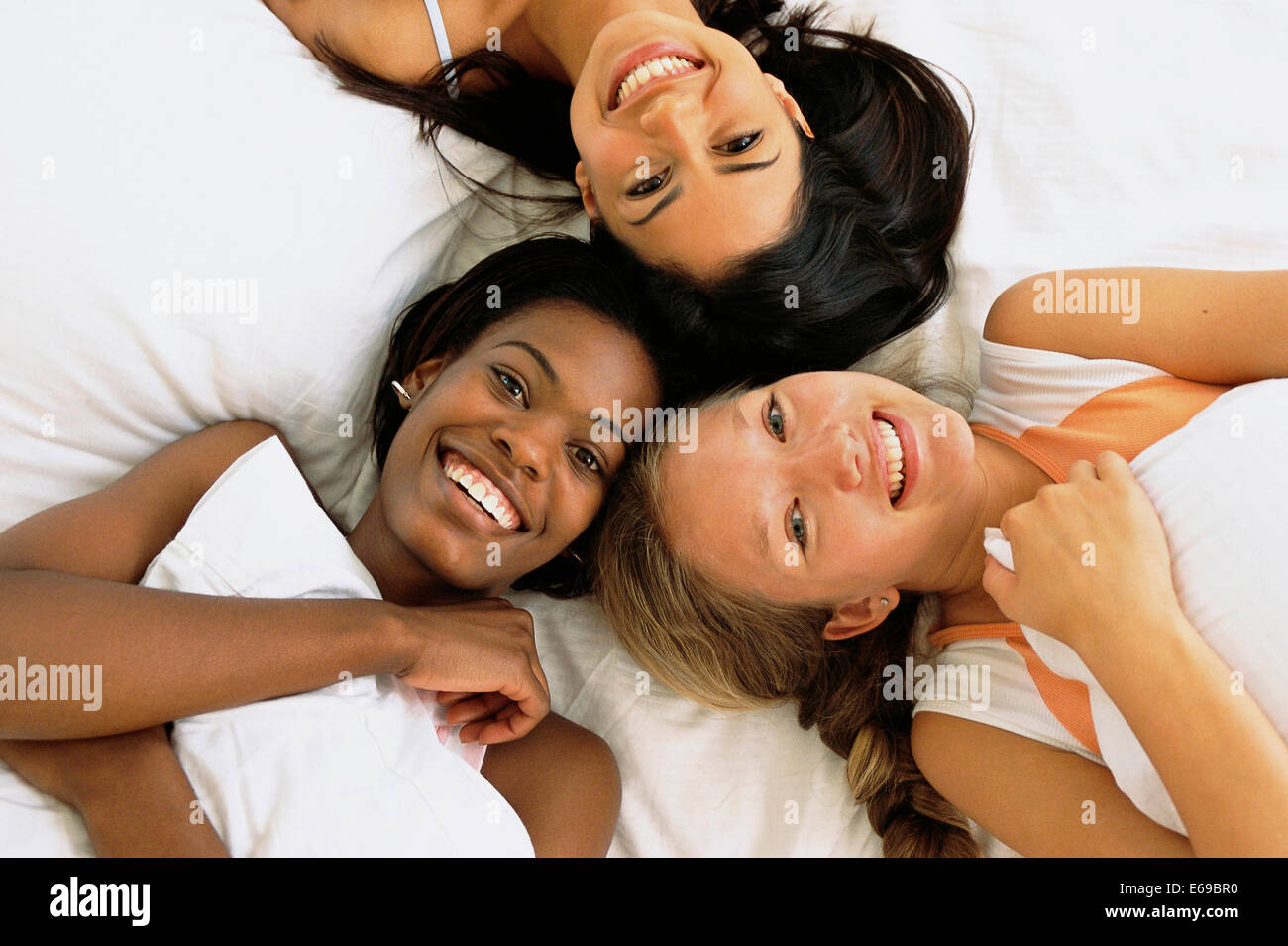 Friends relaxing together on bed Stock Photo - Alamy