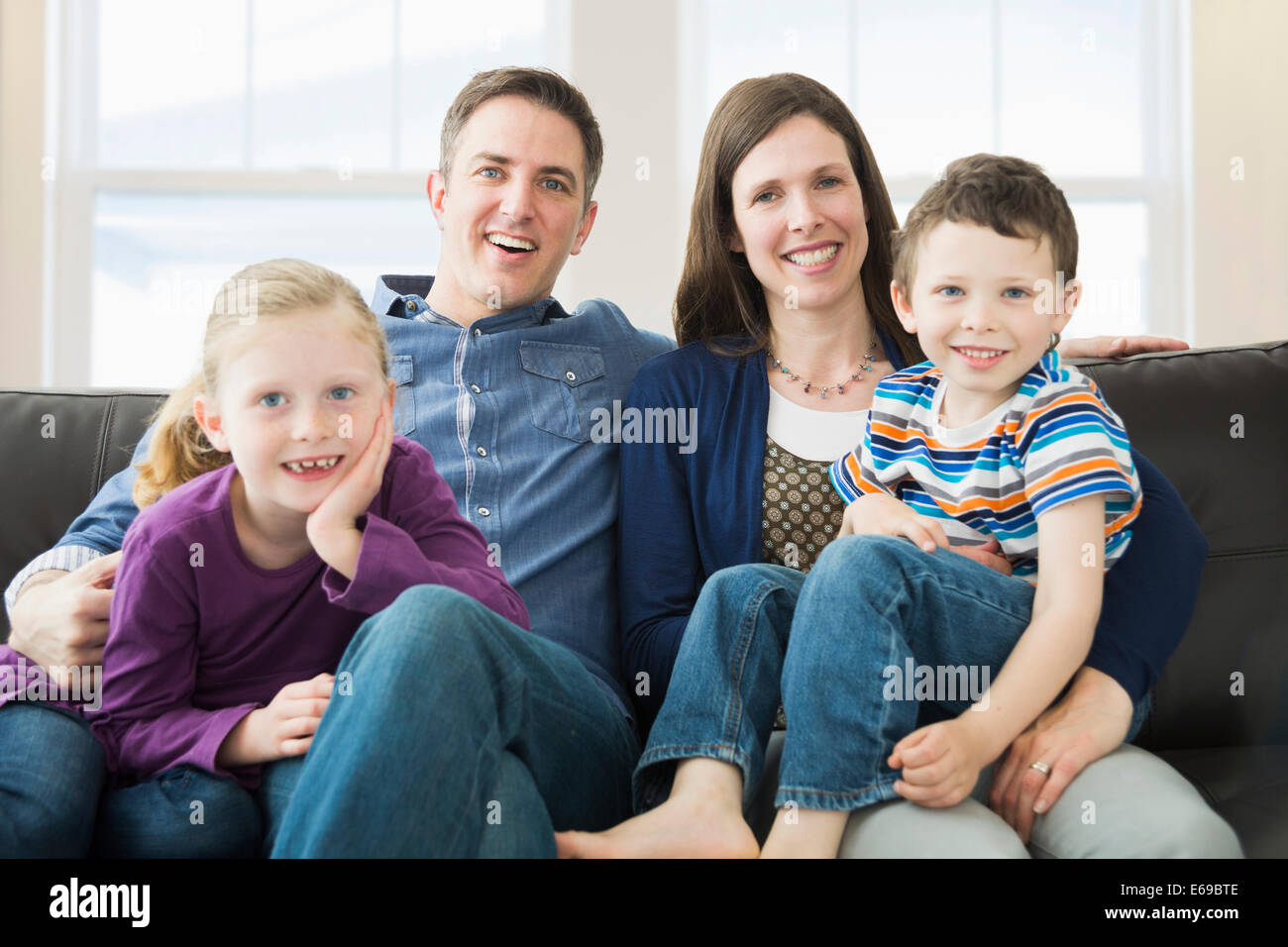 Caucasian family relaxing on sofa Stock Photo - Alamy