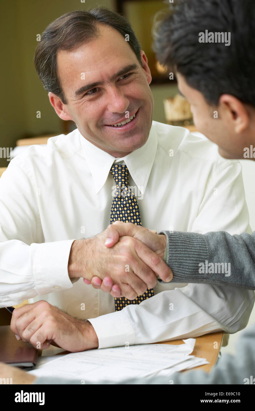 Hispanic man and businessman shaking hands Stock Photo - Alamy