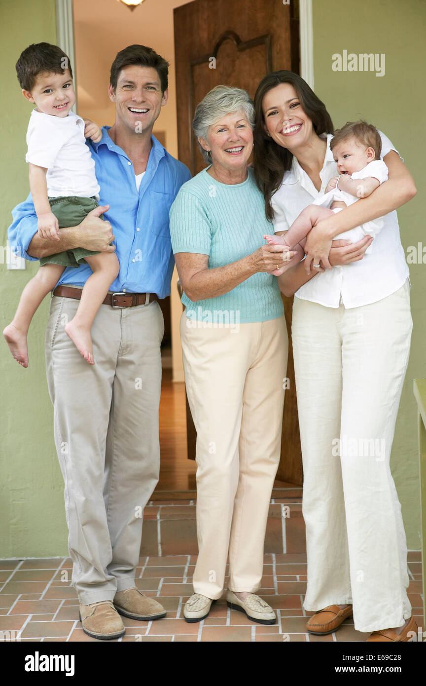 Family smiling together at front door Stock Photo - Alamy