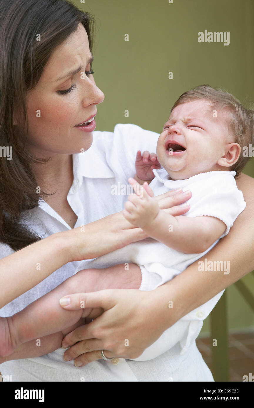 Mother comforting crying baby Stock Photo - Alamy