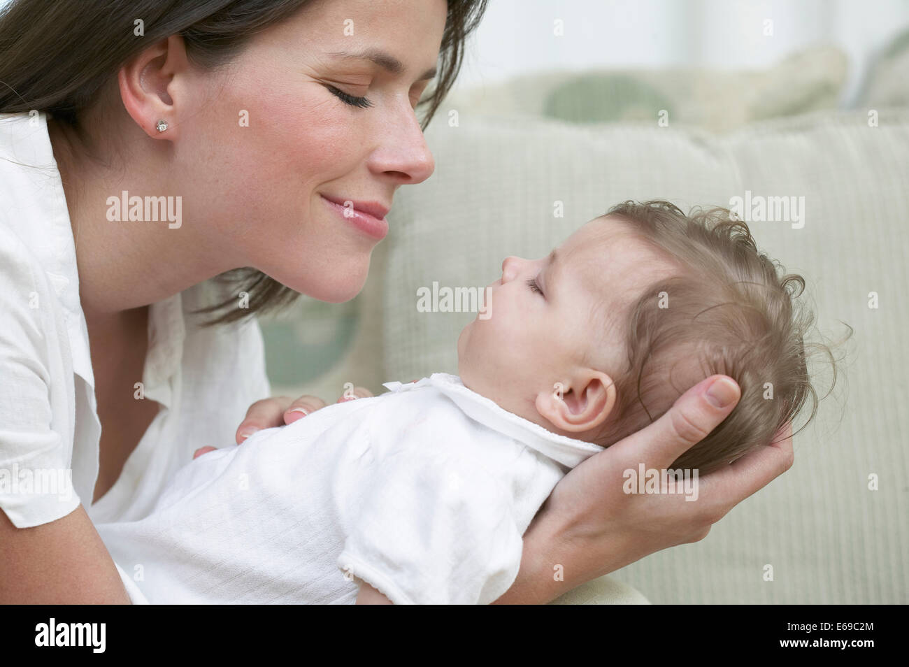 Mother admiring baby on sofa Stock Photo - Alamy