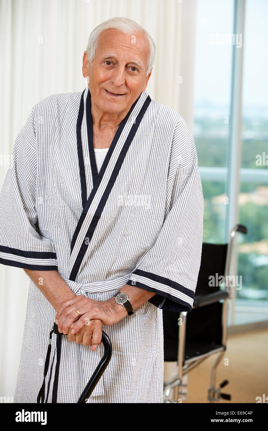Senior man standing with cane Stock Photo - Alamy