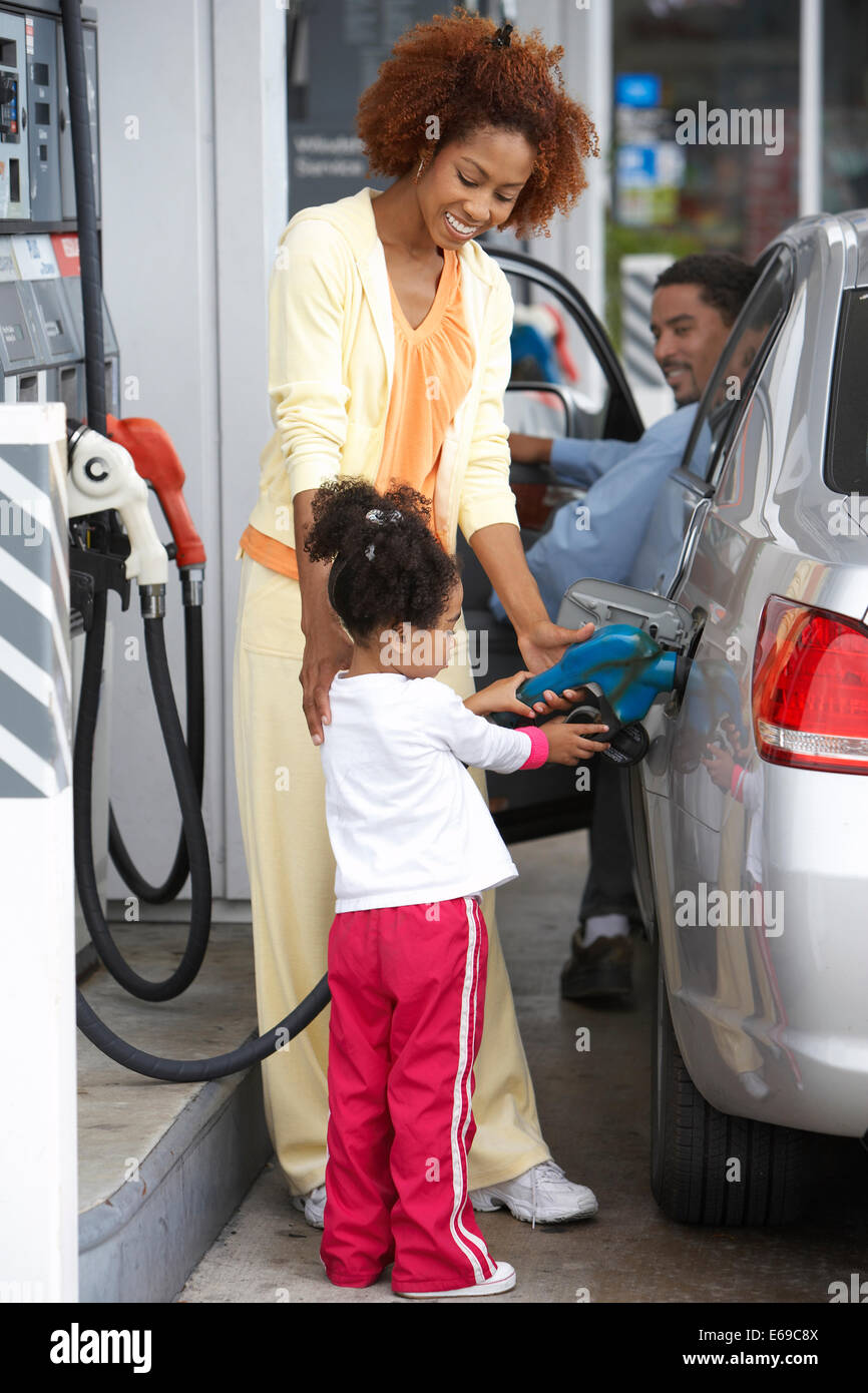 Black mother teaching daughter to pump gas Stock Photo - Alamy