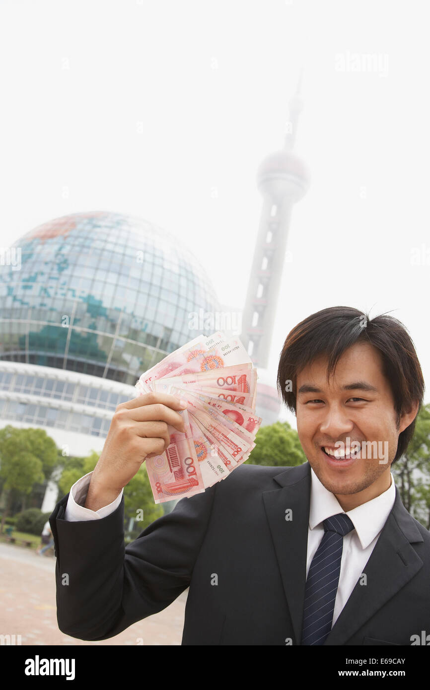 Chinese businessman holding wad of money, Shanghai, China Stock Photo ...