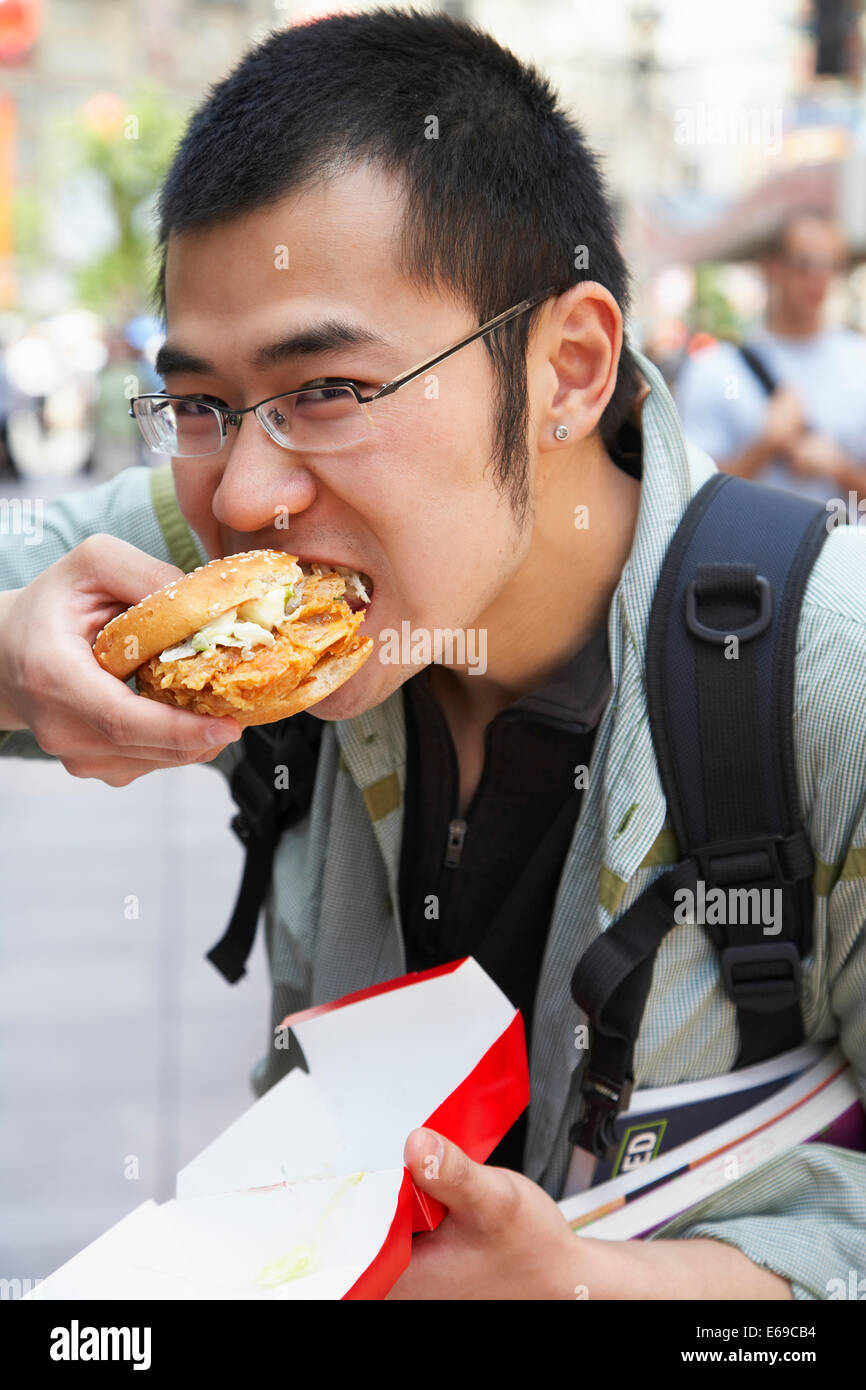 Chinese man eating on city street Stock Photo - Alamy