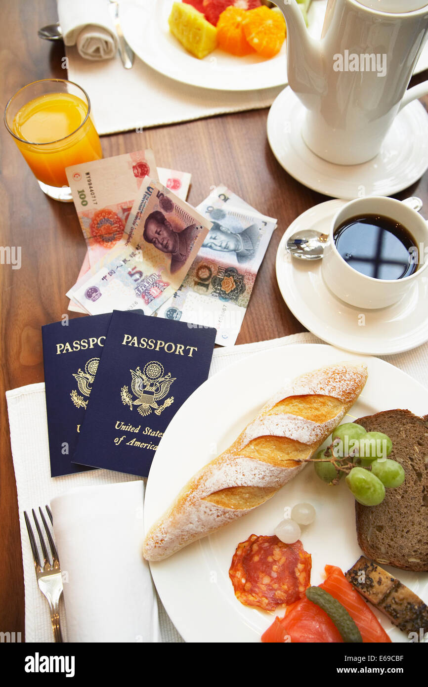 Passports, money and food on breakfast table Stock Photo - Alamy
