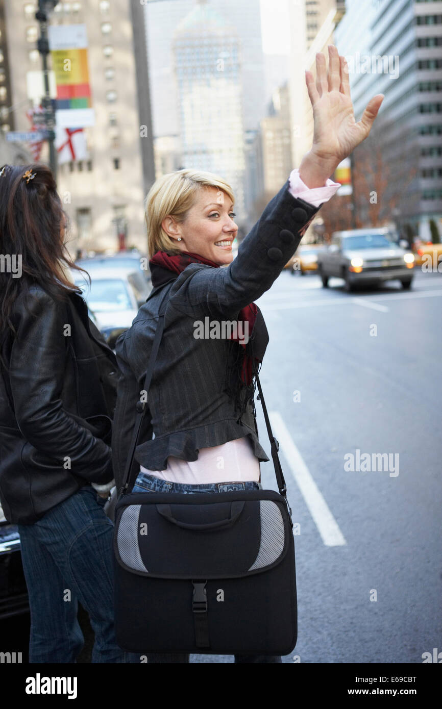 Women hailing taxi on city street Stock Photo - Alamy