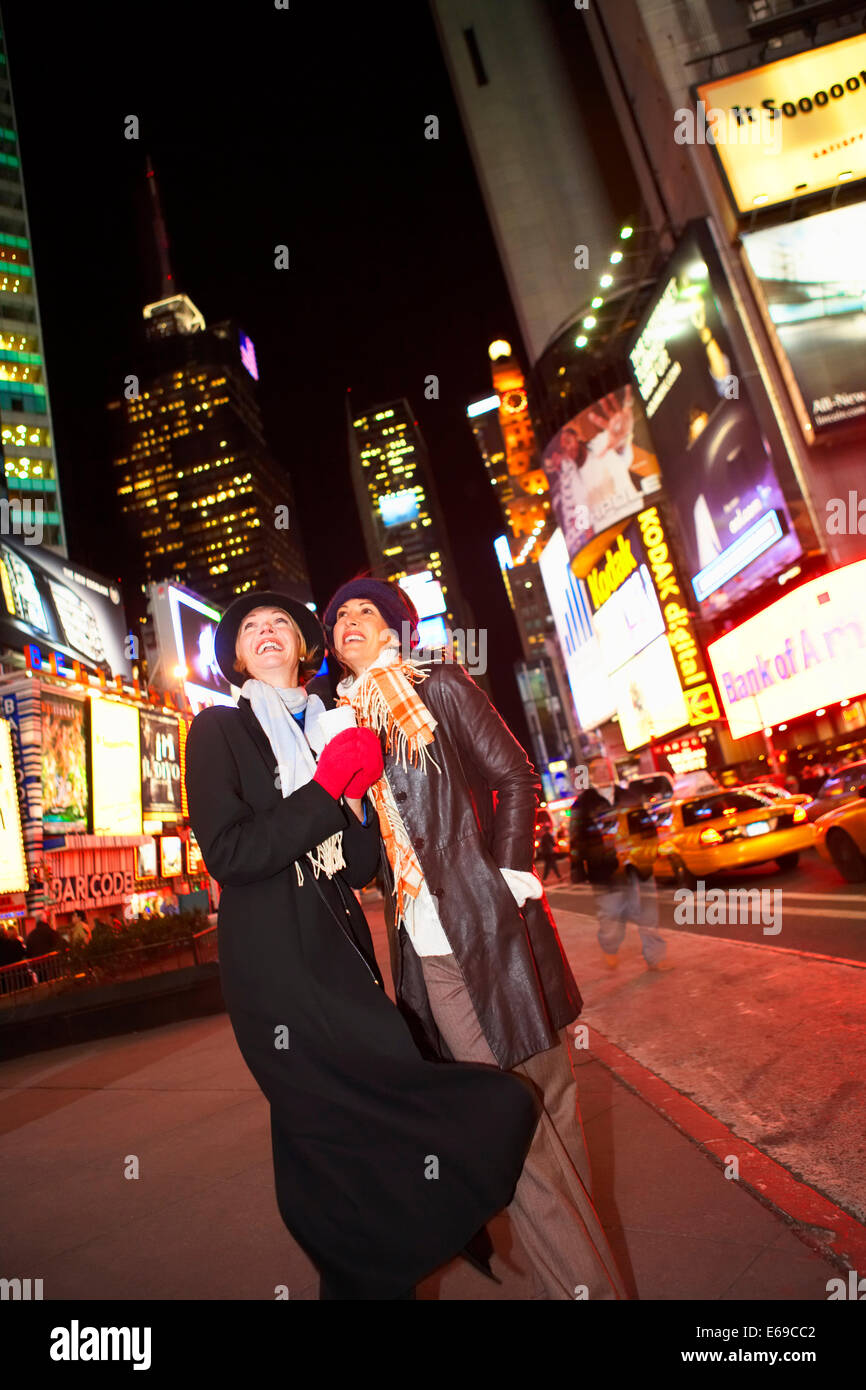 Woman smiling on city street lit up at night Stock Photo - Alamy