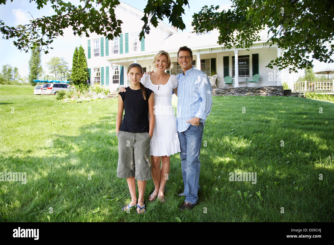 Family standing outside suburban house Stock Photo - Alamy