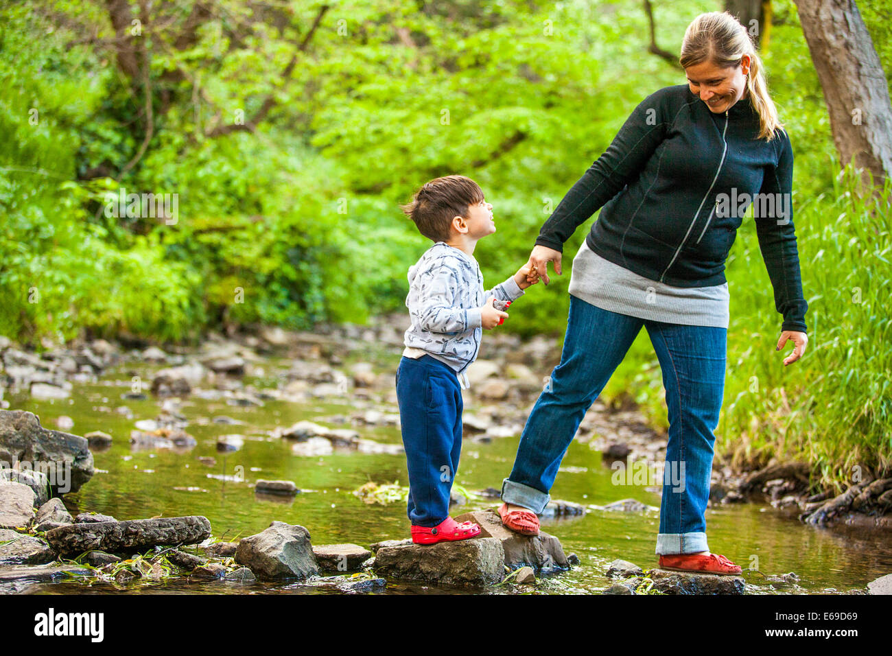 Mother and son exploring rocky creek Stock Photo - Alamy