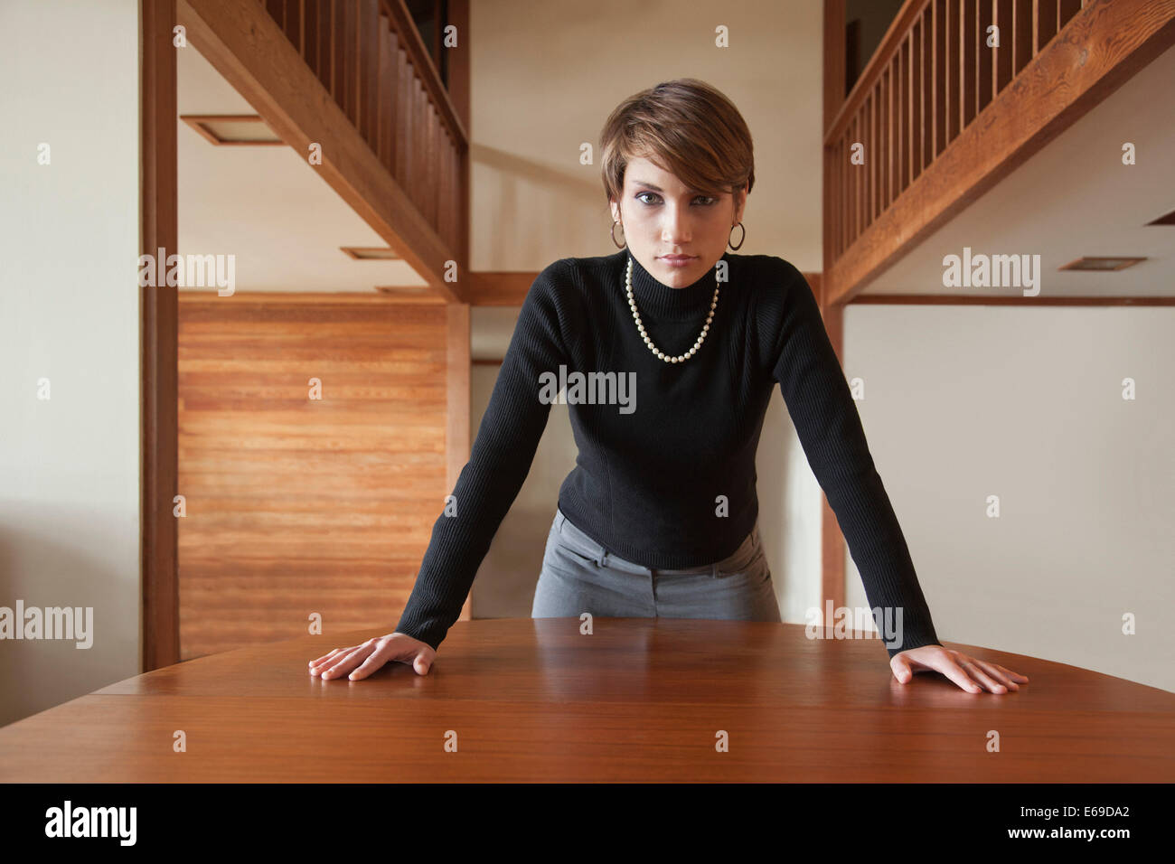Caucasian woman leaning on table Stock Photo - Alamy
